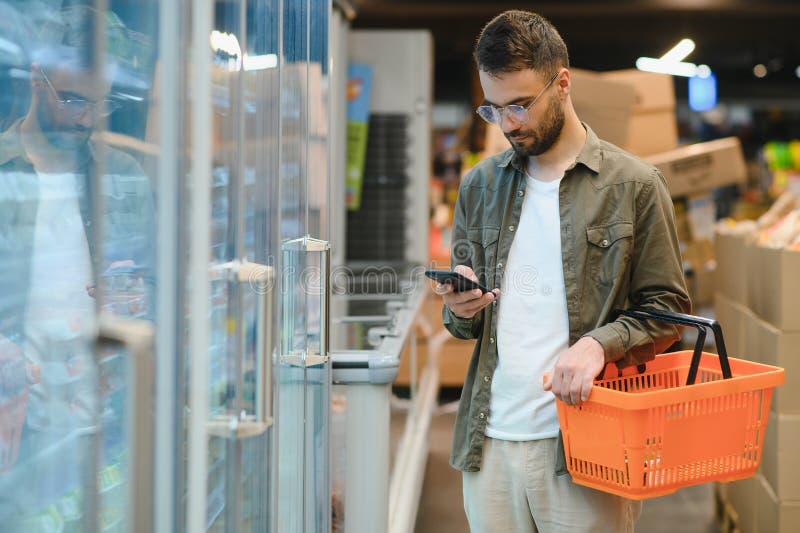 Handsome Young Man Choosing Food in the Supermarket. Stock Photo ...