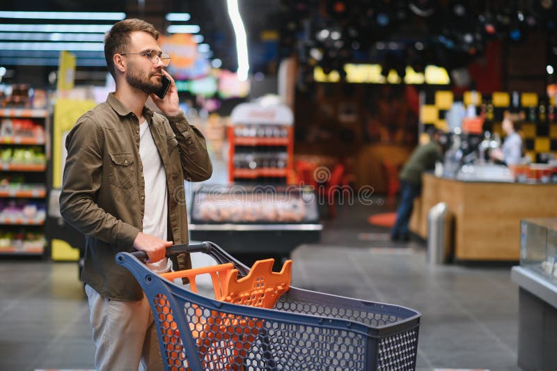 Handsome Young Man Choosing Food in the Supermarket. Stock Photo ...