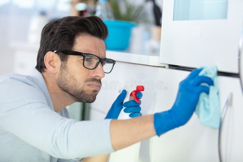 Handsome Young Man Cleaning Kitchen Cabinets Stock Photo - Image of ...
