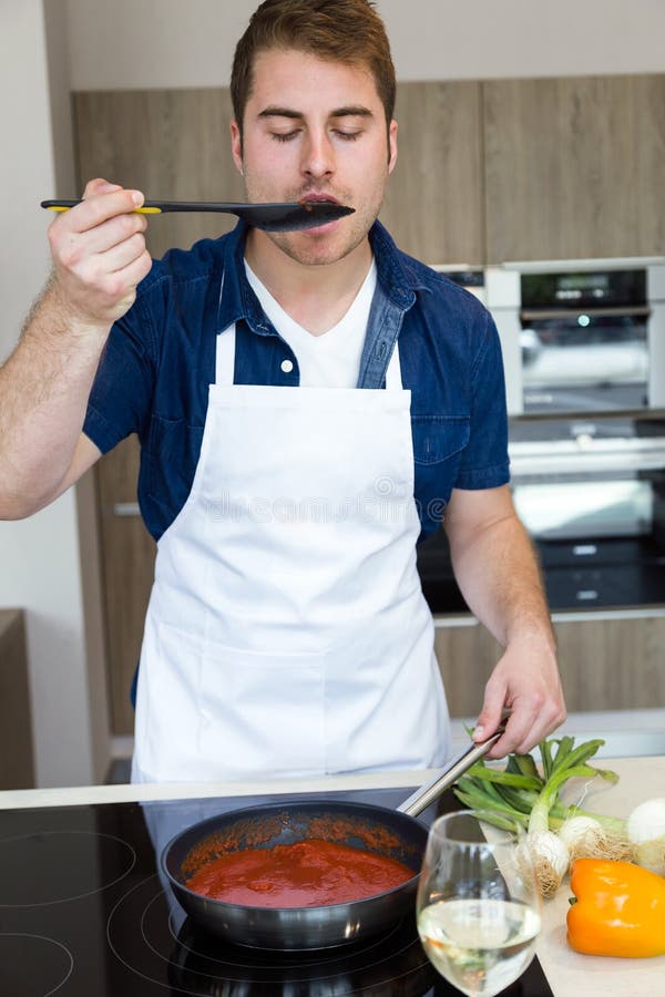 Handsome Young Man Cooking Tomato Sauce in the Kitchen at Home. Stock ...