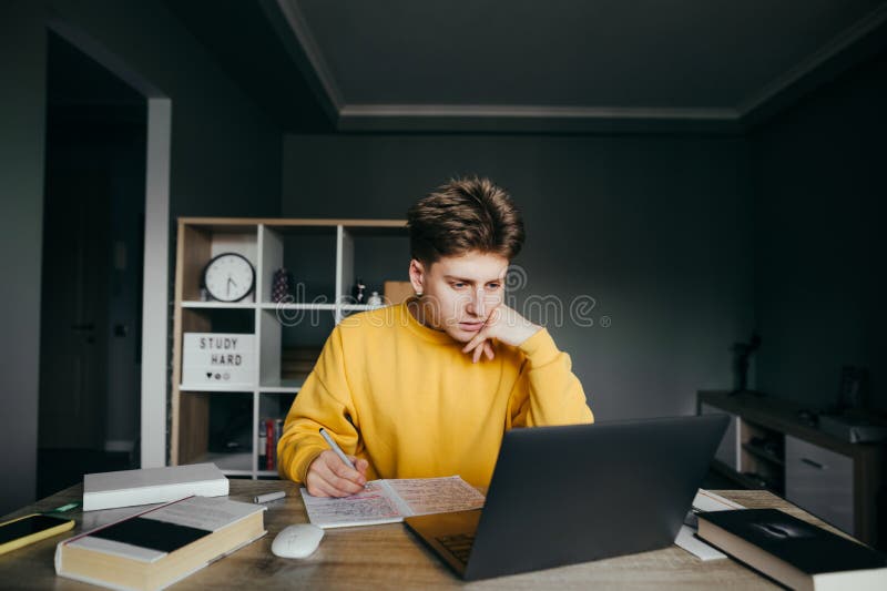 Handsome Young Man Doing Homework on Desktop at Home on Room Background ...