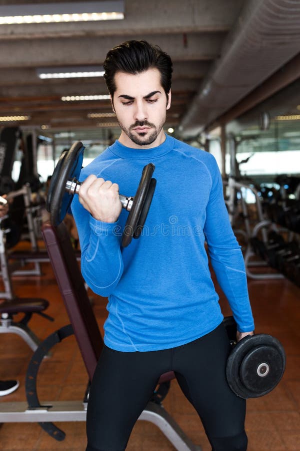 Handsome Young Man Doing Muscular Exercise in Gym. Stock Photo - Image ...