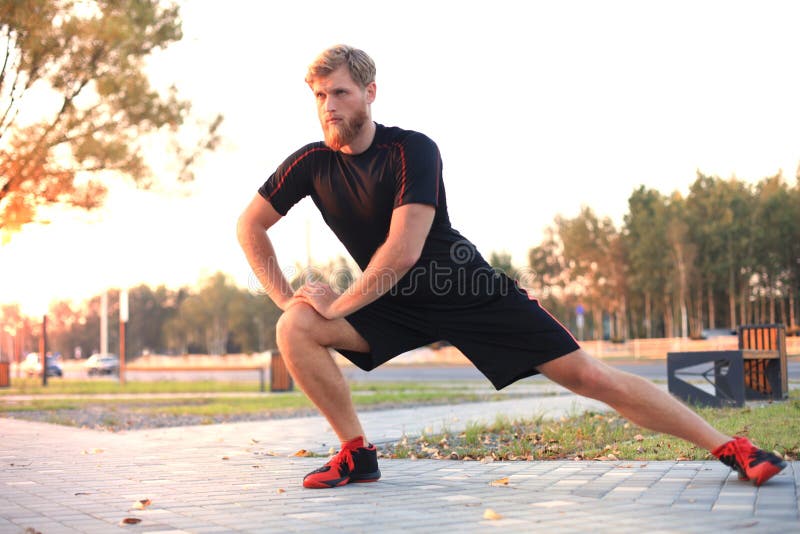 Handsome Young Man Doing Stretching Exercises before Running while ...