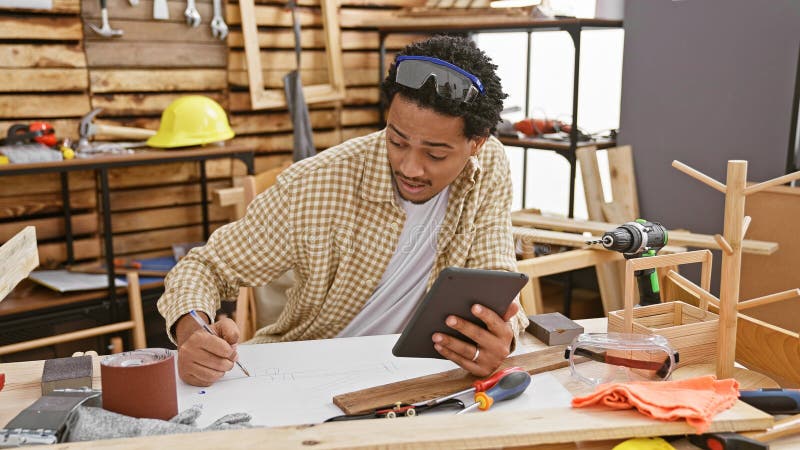 Handsome Young Man Drawing Plans in a Carpentry Workshop while Holding ...
