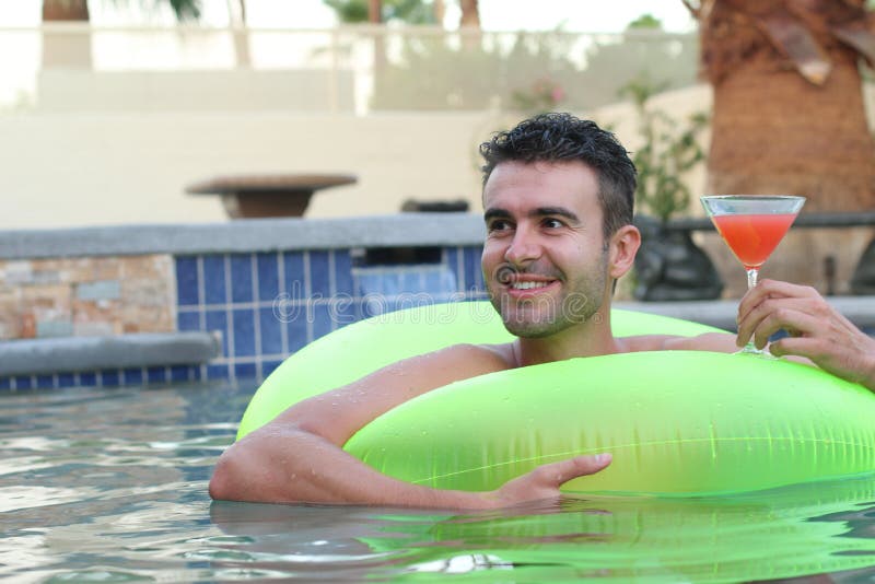 Handsome Young Man Drinking a Cocktail while Relaxing in a Swimming ...