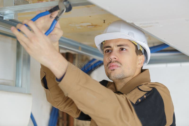 Handsome Young Man Fixing Ceiling Panel with Pliers Stock Image - Image ...