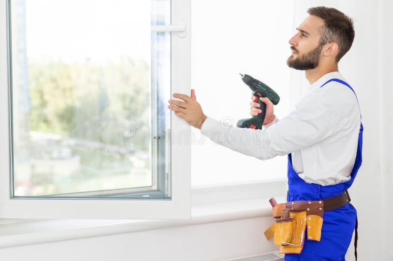 Handsome Young Man Installing Bay Window in a New House Construction ...