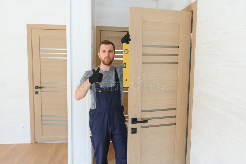 Handsome Young Man Installing a Door in a New House Construction Site ...