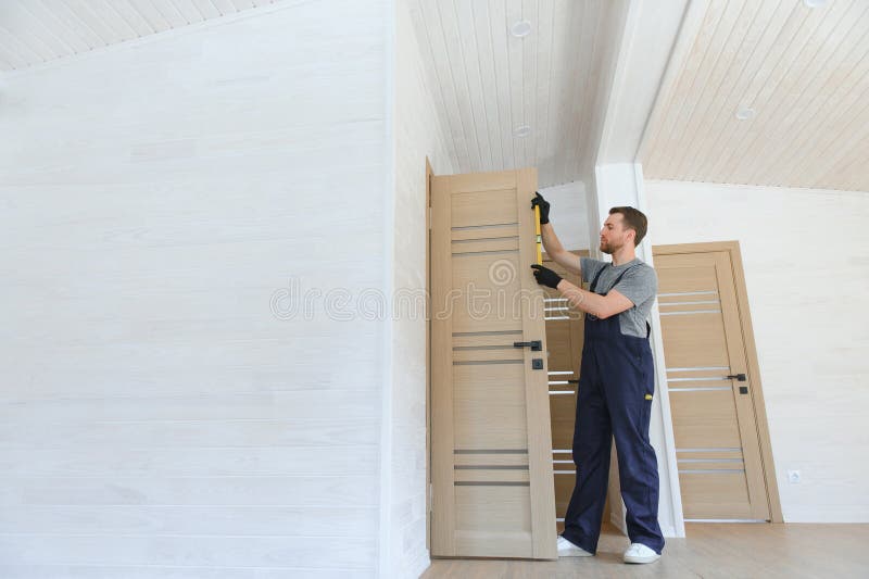 Handsome Young Man Installing a Door in a New House Construction Site ...
