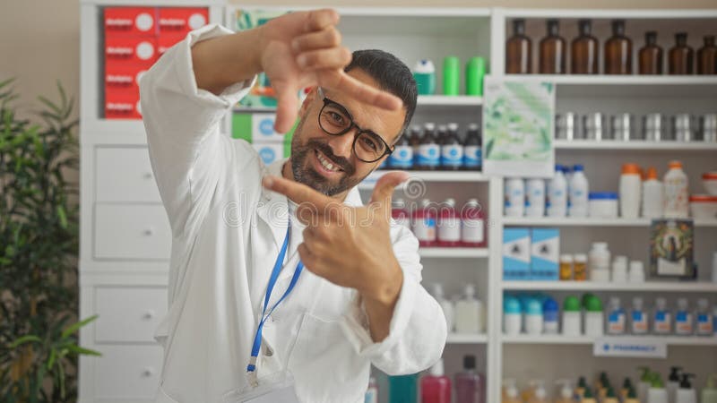 Handsome Young Man in Lab Coat Gesturing Frame with Fingers at Pharmacy ...