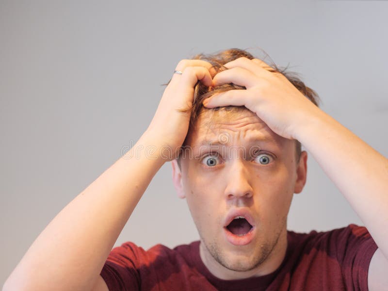 A Handsome Young Man Looking Shocked with His Hands on His Head Stock ...