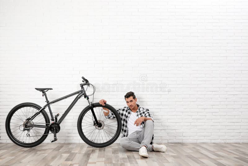 Handsome Young with Modern Bicycle Near White Brick Wall Indoors Stock ...