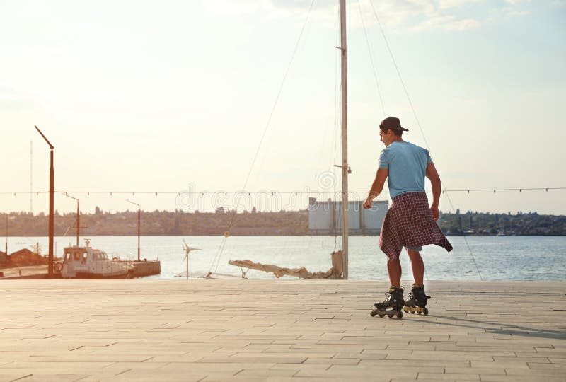 Handsome Young Man Roller Skating on Pier Near River Stock Image ...