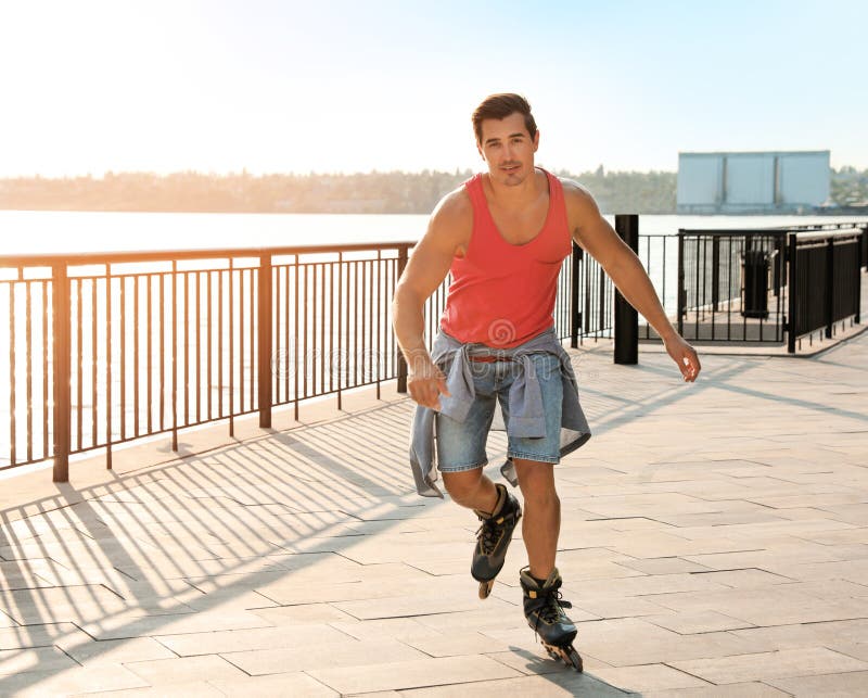 Handsome Young Man Roller Skating on Pier Near River Stock Photo ...