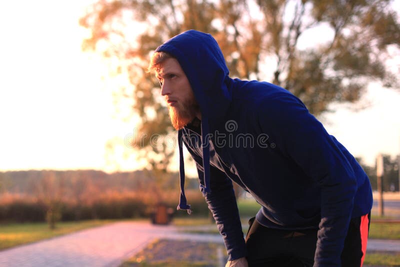 Handsome Young Man after Run Resting after Jog at the Park at Sunset or ...