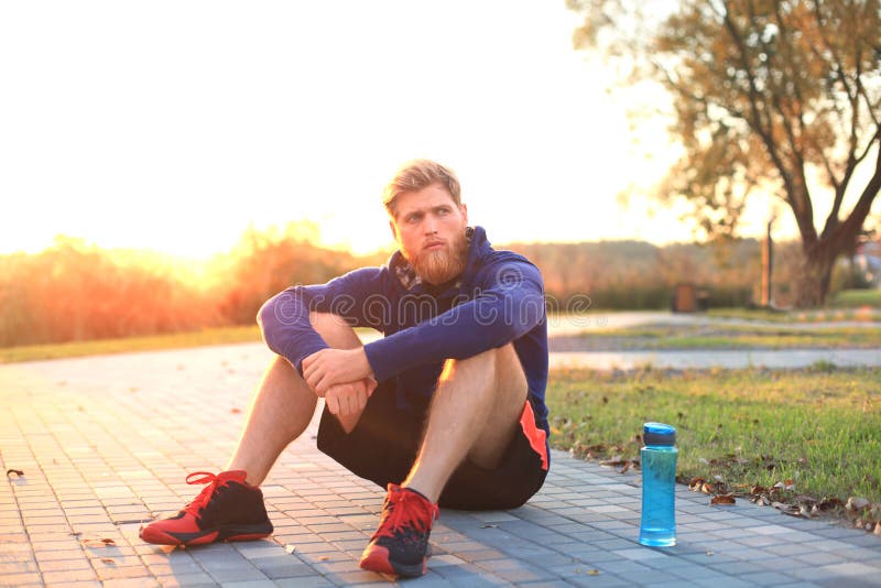 Handsome Young Man after Run Resting after Jog at the Park at Sunset or ...