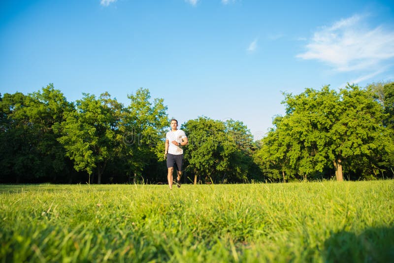 A Handsome Young Man Running in a Park Stock Photo - Image of exercise ...