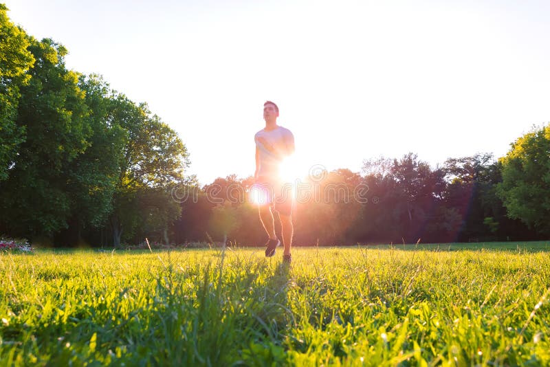 A Handsome Young Man Running during Sunset in a Park Stock Photo ...