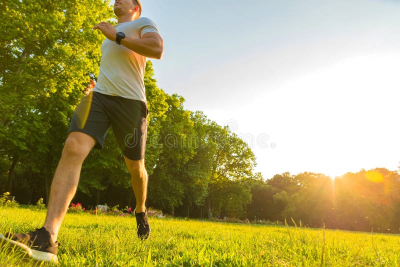 A Handsome Young Man Running during Sunset in a Park Stock Photo ...