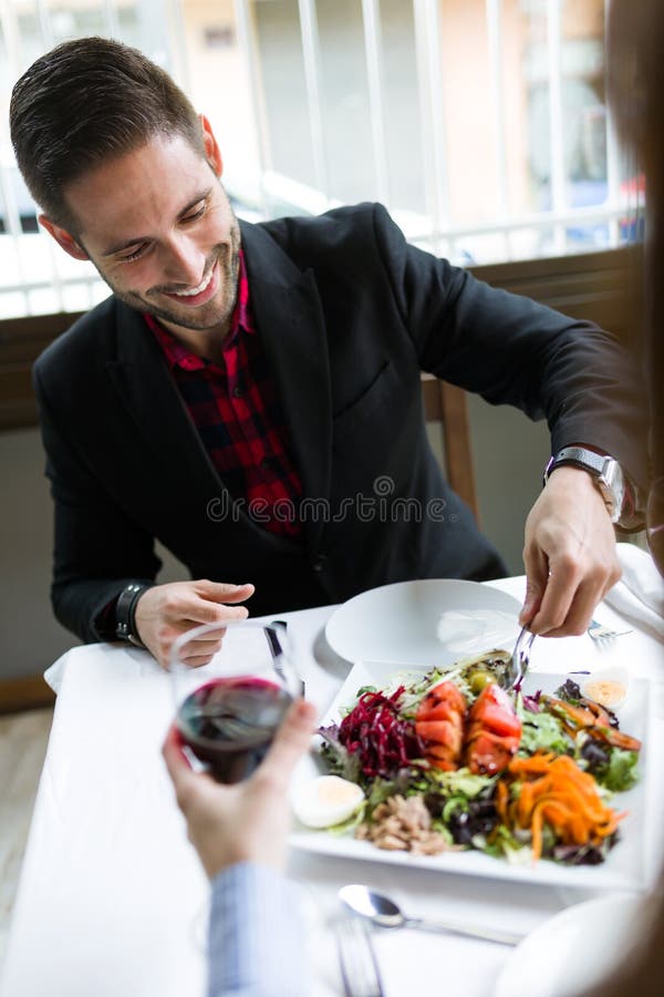 Handsome Young Man Serving Salad on a Plate in the Restaurant. Stock ...