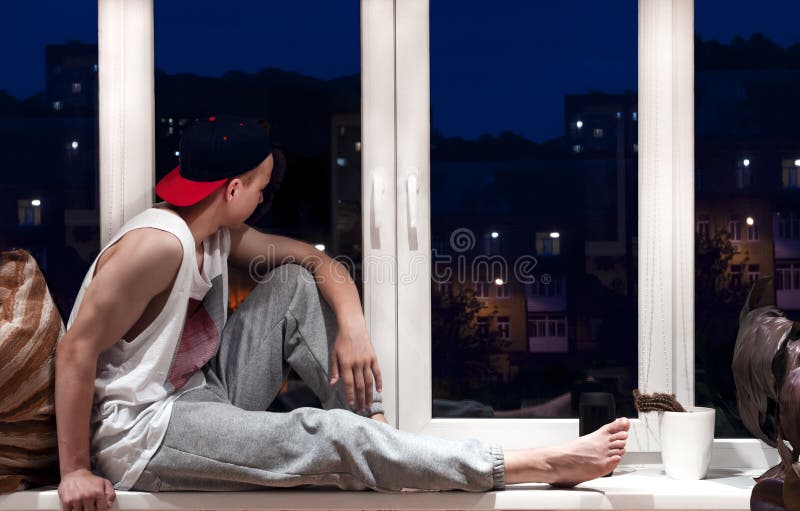 Handsome Young Man Sitting Near Window in the Evening Stock Photo ...