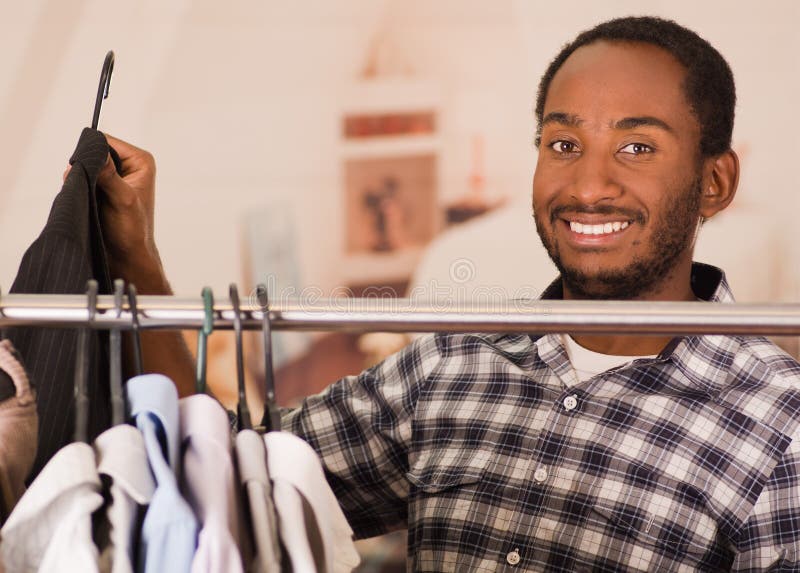 Handsome Young Man Standing Inside Wardrobe Going through Rack of ...