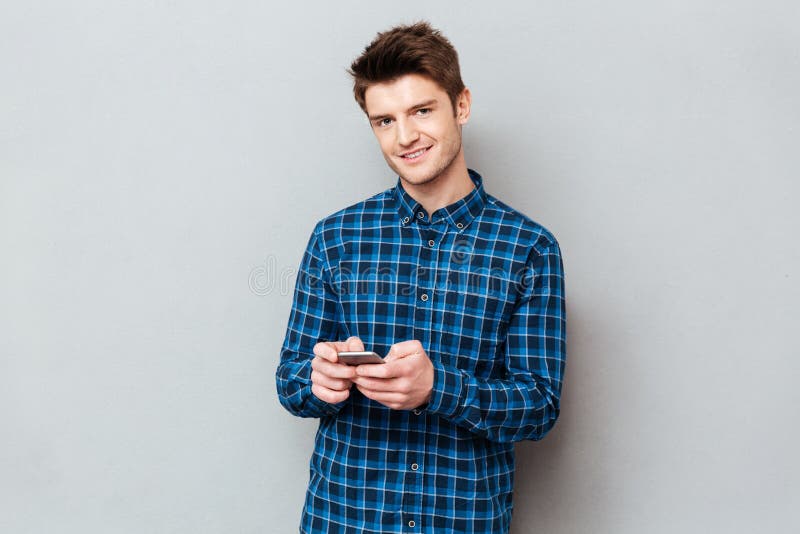 Handsome Young Man Standing Over Grey Wall and Chatting Stock Photo ...