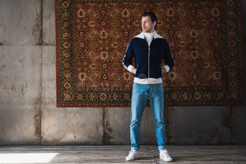 Handsome Young Man in Stylish Clothes in Front of Rug Hanging Stock ...