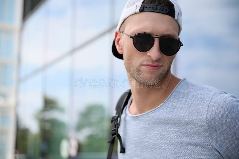 Handsome Young Man with Stylish Sunglasses and Backpack Near Reflection ...