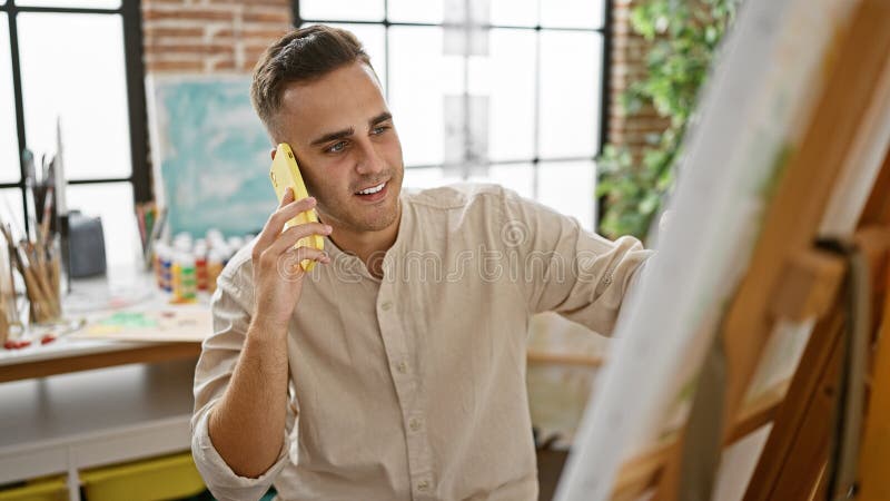 Handsome Young Man Talking on Smartphone while Painting on Canvas in ...