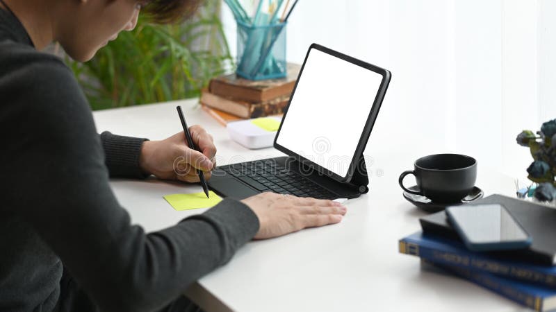 Handsome Young Man Using Computer Tablet and Making Note on Notebook ...