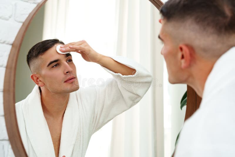 Handsome Young Man Using Cotton Pad on His Face in Bathroom Stock Image ...