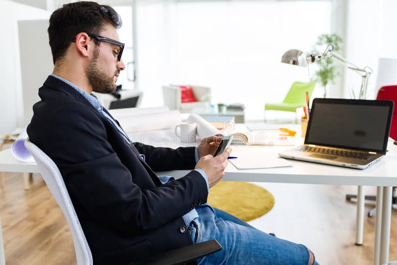 Handsome Young Man Using His Mobile Phone in the Office. Stock Photo ...