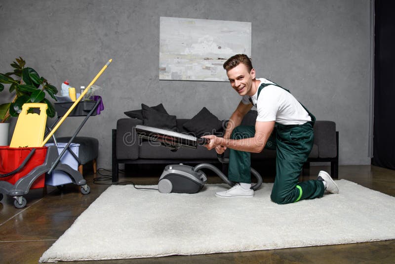 Handsome Young Man Using Vacuum Cleaner and Smiling at Camera ...