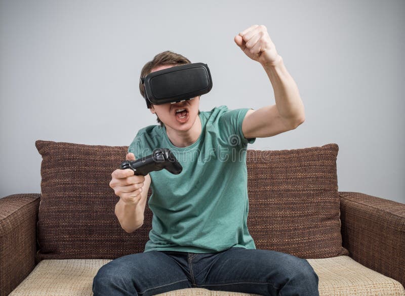 Cheerful gamer on couch stock photo. Image of pastime - 114126802