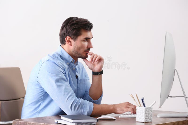 Handsome Young Man Working with Computer at Table in Stock Photo ...