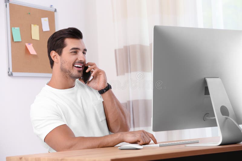 Handsome Young Man Working with and Computer at Table in Office Stock ...