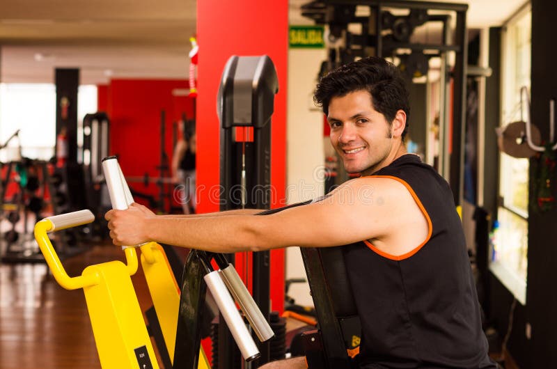 Handsome Young Man Working on Fitness Machine at Gym Stock Photo ...