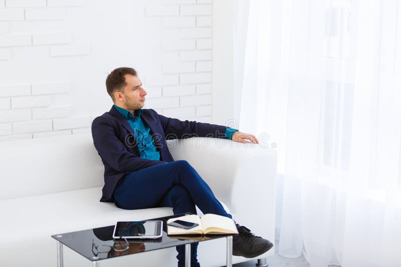 Handsome Young Man Working while Sitting on the Couch in Office Stock ...