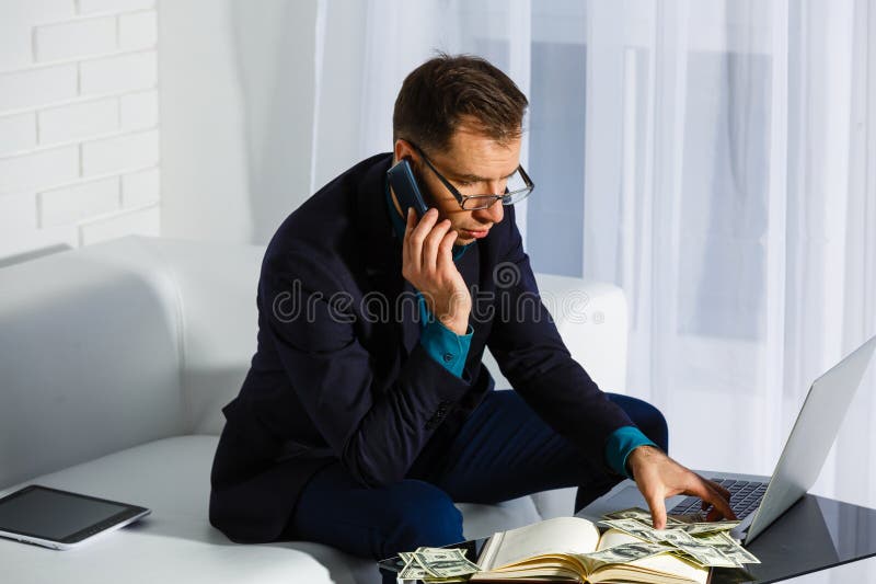 Handsome Young Man Working while Sitting on the Couch in Office Stock ...