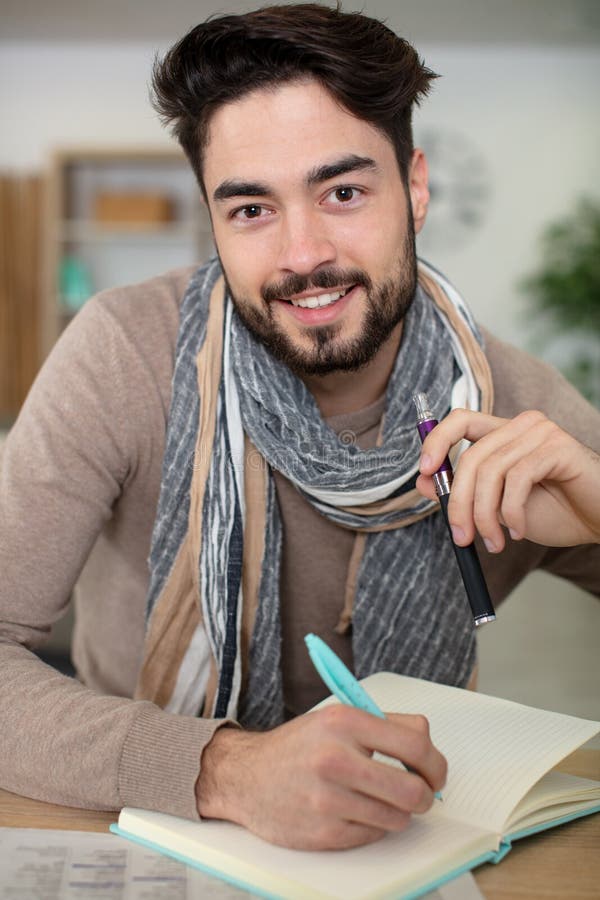 Handsome Young Man Writing Something in Note Pad Stock Image - Image of ...