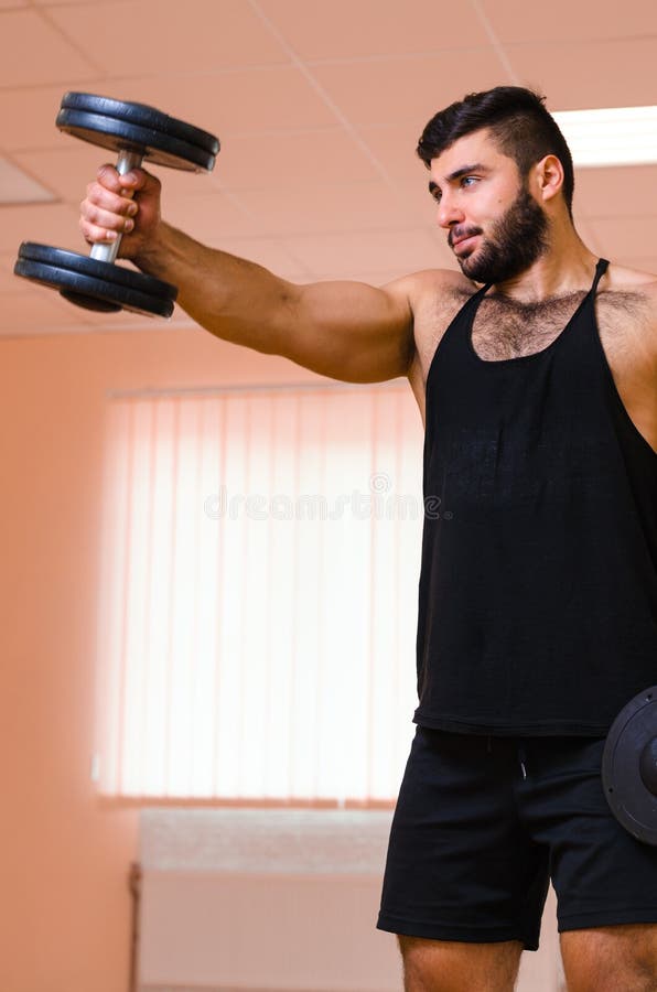 Handsome Young Muscular Man Exercising with Dumbbells. Stock Photo ...