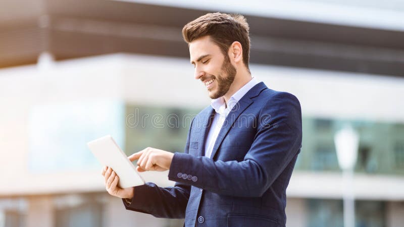 Handsome Young Office Worker with Tablet Computer Browsing Web on City ...