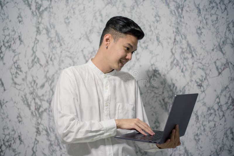 Handsome Young Smiling is Holding a Notebook and Smiling at Office ...