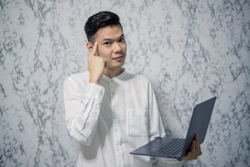 Handsome Young Smiling is Holding a Notebook and Smiling at Office ...