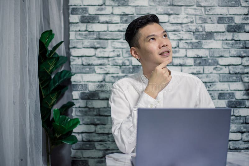 Handsome Young Thinking while Serious Working at Home with Laptop on ...