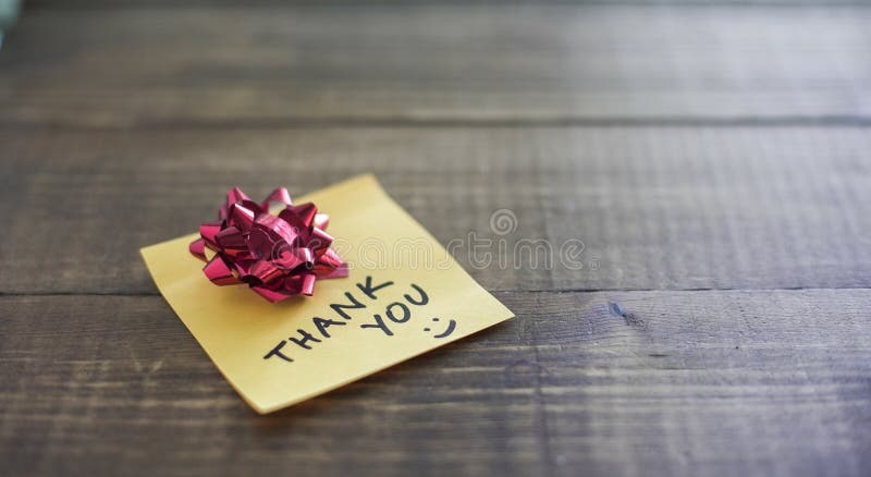 A Handwritten Thank You Note with a Red Bow on a Wooden Surface Stock ...