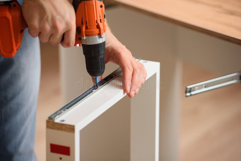 A Handyman Assembles a New Table with a Screwdriver. Handyman Stock ...
