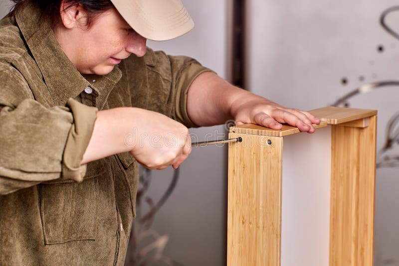 Handyman Is Assembling Drawer Of Flat Pack Furniture By Screwdriver