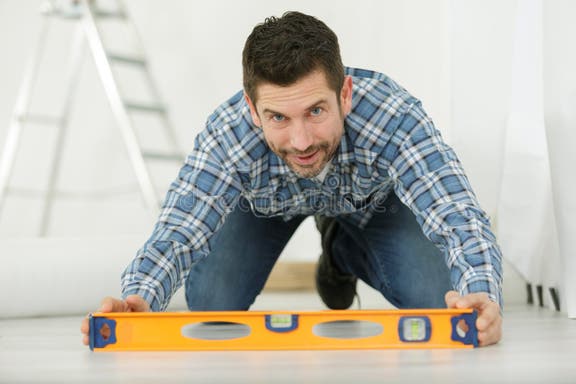 Handyman check floor level stock photo. Image of level - 172602910